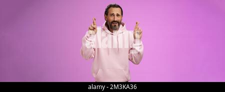 Nervous unsure hopeful handsome bearded 40s man in pink stylish hoodie ...