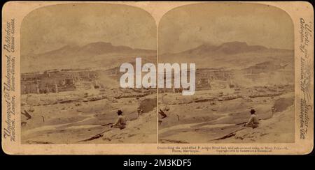 Overlooking the mud-filled Roxelane River bed, and ash-covered ruins ...