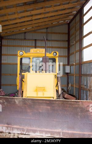 Large wheeled tractor with a dozer blade for clearing roads from snow ...