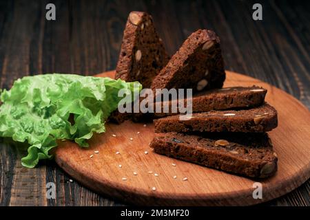 lettuce leaves and rye bread with pine nuts on a wooden board Stock ...