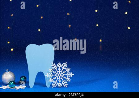 Christmas dentistry - tooth, snowflakes and balls on a blue festive ...