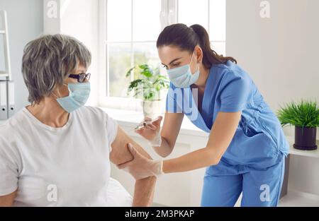 Nurse giving injection to an elderly woman vaccination hospital Stock ...