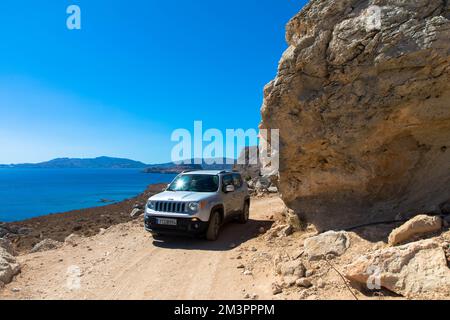 Vacation with a rental car. 4x4 off-road Jeep Renegade on dirt road on ...