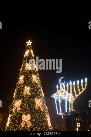 A decorated Christmas tree with illuminated Hanukkah menorah and the ...
