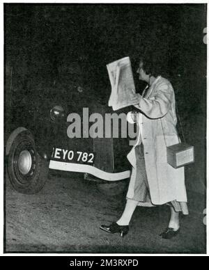 World War II: Blackout. Woman fitting blackout shields to the headlamps ...