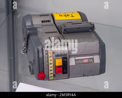 London transport 1970s bus ticket machine inside the bus. Commuters and ...