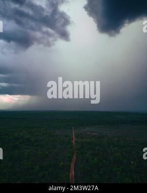 Aerial view of a straight dirt road cutting through a sparsely ...