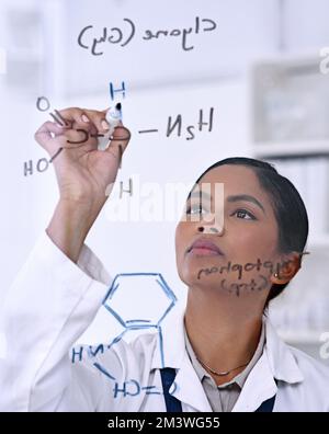 Creating a new formula. an attractive young female scientist working on ...