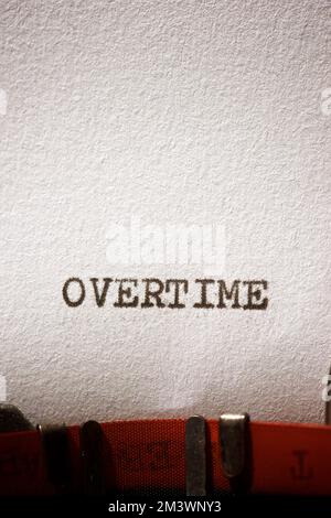 Overtime word written with a typewriter Stock Photo - Alamy