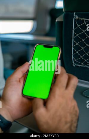 Unidentified man holding a smartphone with green screen Stock Photo - Alamy
