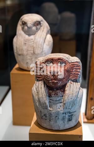 An ancient Egyptian canopic jar featuring a sculpted figure with a ...