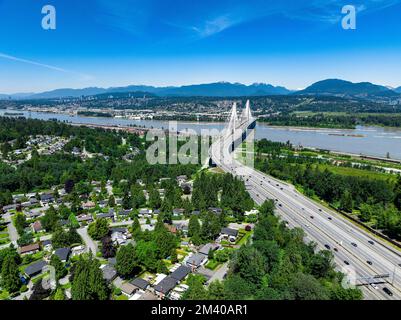 A drone shot of Coquitlam cityscape with Port Mann Bridge, river and ...