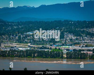 A drone shot of Coquitlam cityscape with Port Mann Bridge, river and ...
