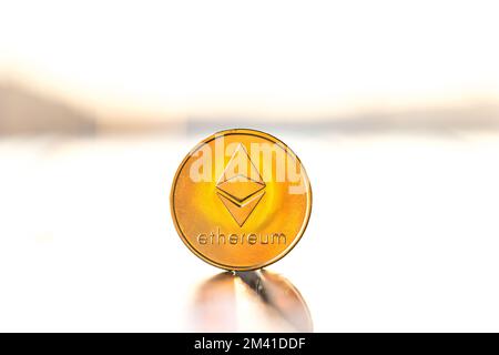 Ethereum gold color coin with sunset white background. Cryptocurrency ...