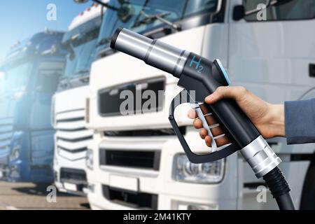 Hand with H2 nozzle on a background of hydrogen filling station. Clean ...