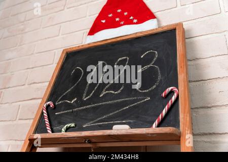 a black slate on which the year 2023 is written in chalk. Happy New ...