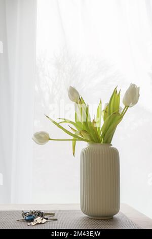 Withering flowers in a vase and keys left on the table. Concept Stock ...