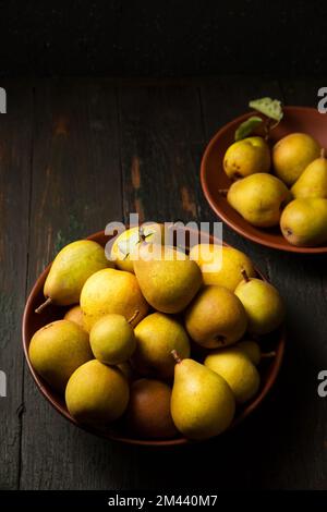 Delicious juicy homemade pears in clay plates on dark background in ...