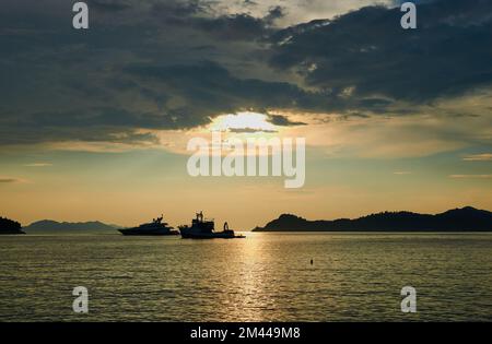 A panoramic view of silhouettes of yachts floating on the sea under the ...