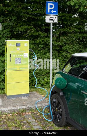 Car park with charging station, car, mini, electric car is charged at ...