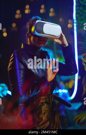stylish female in metaverse in vr headset pressing the button in the air Stock Photo - Alamy