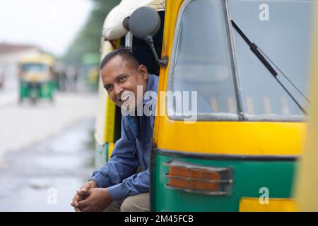 Portrait of a happy auto rickshaw driver looking back Stock Photo - Alamy