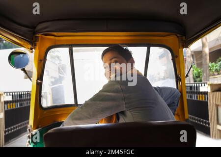 Portrait of a happy auto rickshaw driver looking back Stock Photo - Alamy