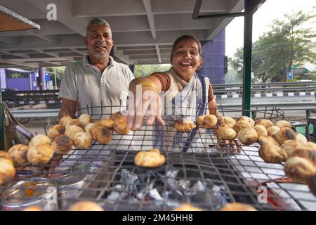 Senior couple making litti at his roadside food stall Stock Photo - Alamy
