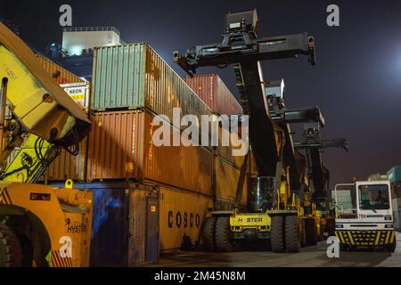 Reach Stacker during operation. Reach-stacker container loader during night work. Industrial ...