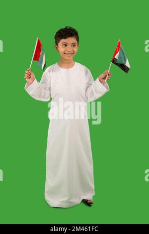 Portrait of an Arab boy holding a UAE national flag Stock Photo - Alamy