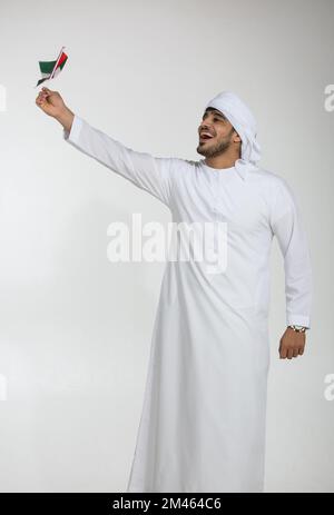 Emirati man holding the UAE national flag Stock Photo - Alamy