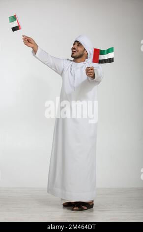 Emirati man holding the UAE national flag Stock Photo - Alamy