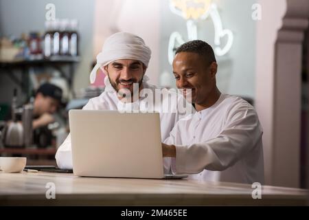 Emirati men working in a cafe Stock Photo - Alamy