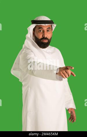 Arab man with beard looking and pointing at huge smartphone with empty ...