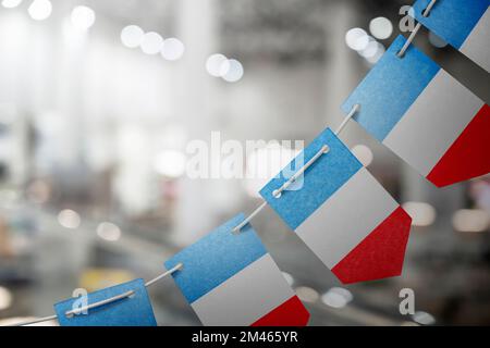 A garland of France national flags on an abstract blurred background ...