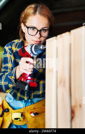 Female carpenter using vertical drill machine Stock Photo - Alamy