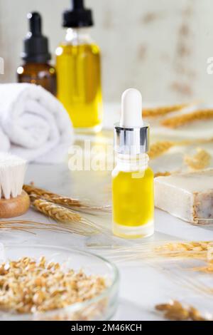 Hair brush, towel, essential oil and cotton balls on white background ...