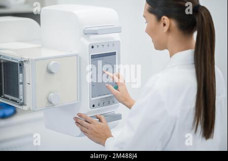 Pretty young female doctor dealing with the medical equipment Stock ...