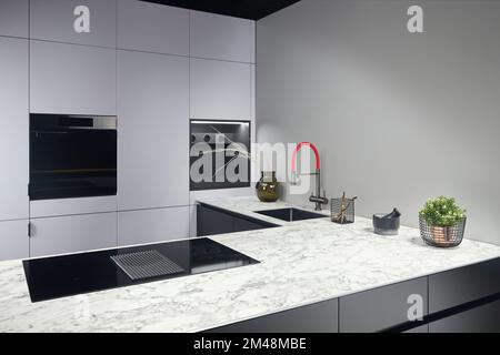 Upscale flat design kitchen with induction black glass hob with ...