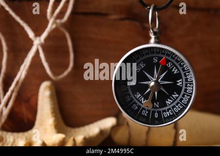 Compass hanging on wooden background, closeup Stock Photo - Alamy