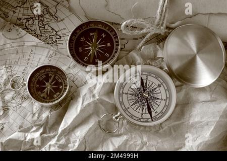 Different vintage compasses on world map Stock Photo - Alamy