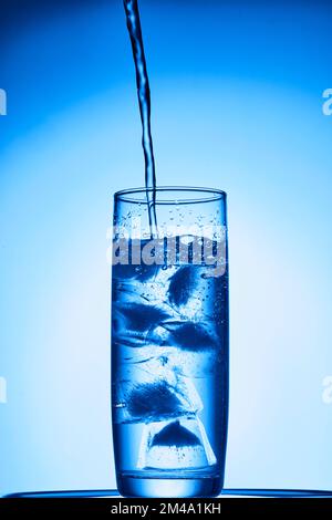 Drops of water falling into deep blue water Stock Photo - Alamy