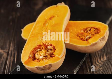 Pumpkin pear-shaped on black stone on wooden background Stock Photo - Alamy