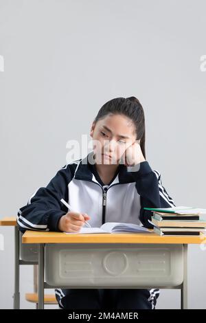 Chinese student thinking in classroom Stock Photo - Alamy