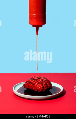 Edible fake brain with fake blood placed on white round plate on red ...