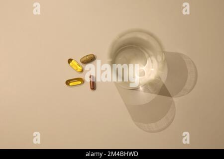 Many kinds of medicine and cup of water on the white table, nutritional ...