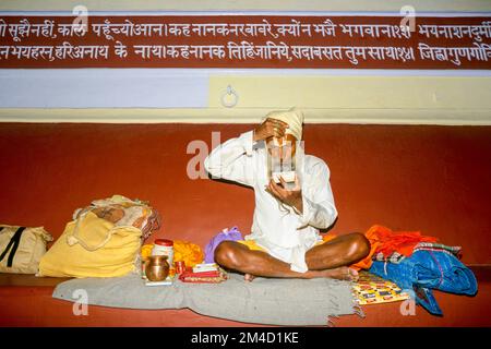Rama-Sadhu painting a fresh tilak on his forehead on the ghats of ...