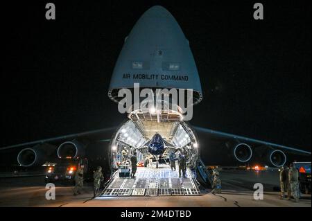 The fuselage of an F-22 Raptor is about to emerge from inside a C-5M ...