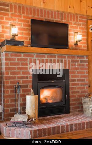 Red brick wood burning fireplace in living room inside log home Stock ...