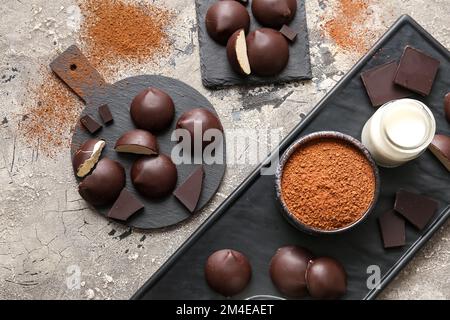 Boards with sweet chocolate bird's milk candies and pitcher of milk on ...